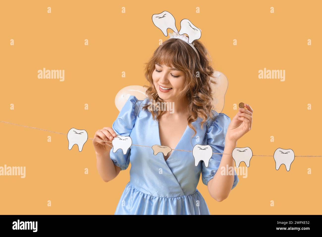 Tooth Fairy with coin and paper teeth on yellow background Stock Photo ...