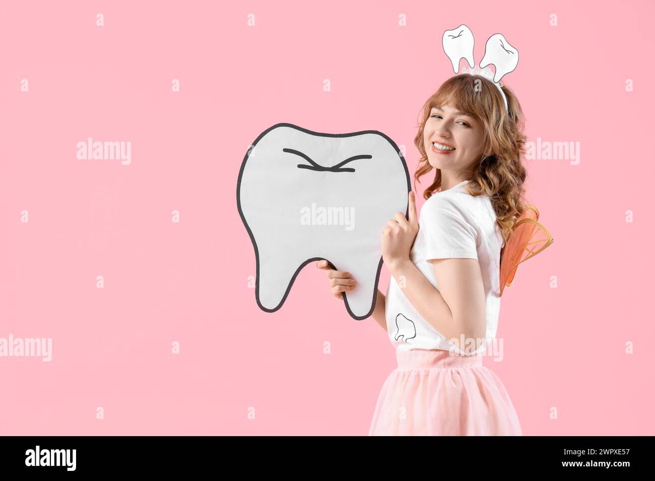 Tooth Fairy with paper figure on pink background Stock Photo - Alamy