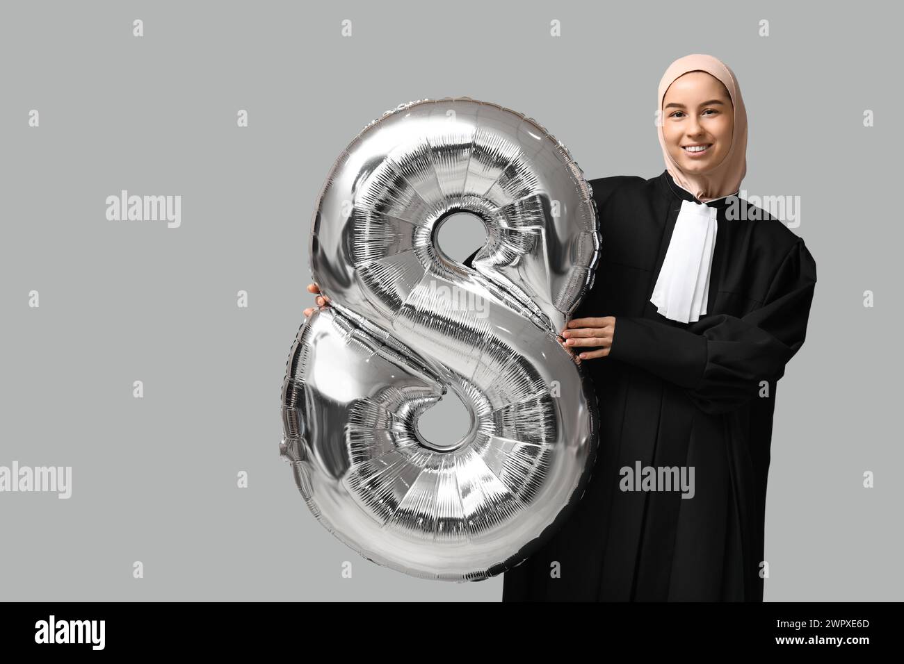 Muslim female judge with balloon in shape of figure 8 on white ...