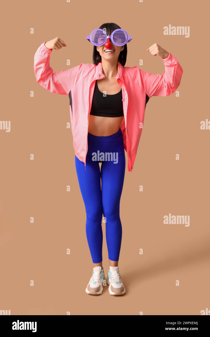 Young smiling female fitness trainer with funny glasses showing ...