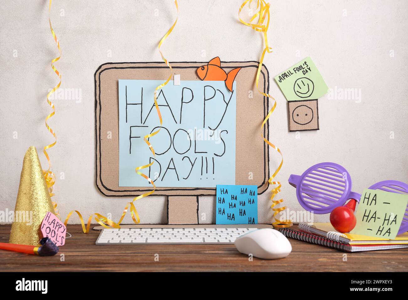 Carton computer screen, keyboard and sticky notes on wooden table ...