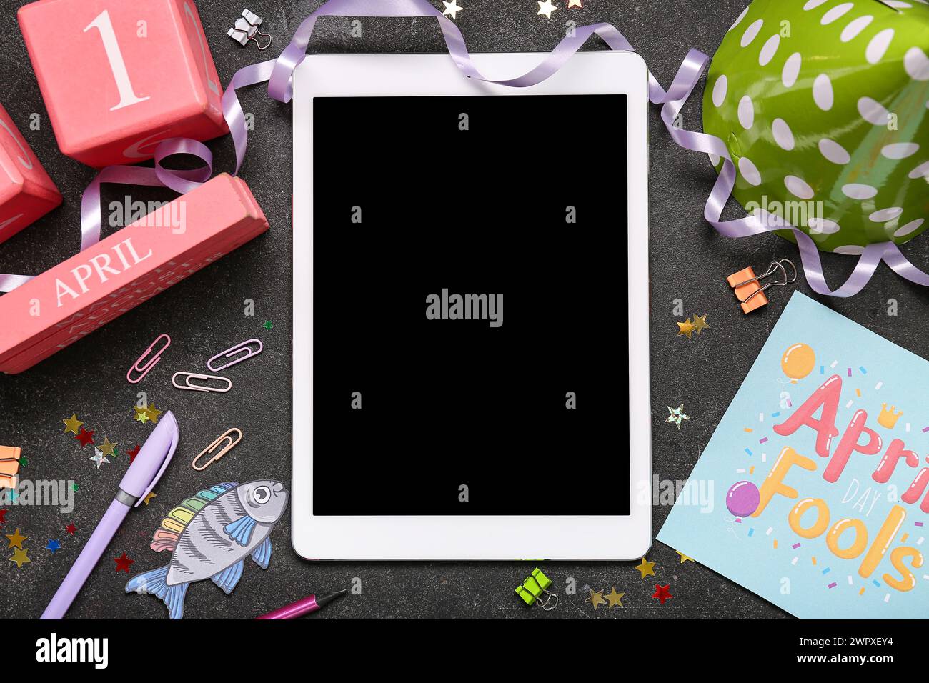 Modern tablet, sticky notes and calendar on black background. April ...