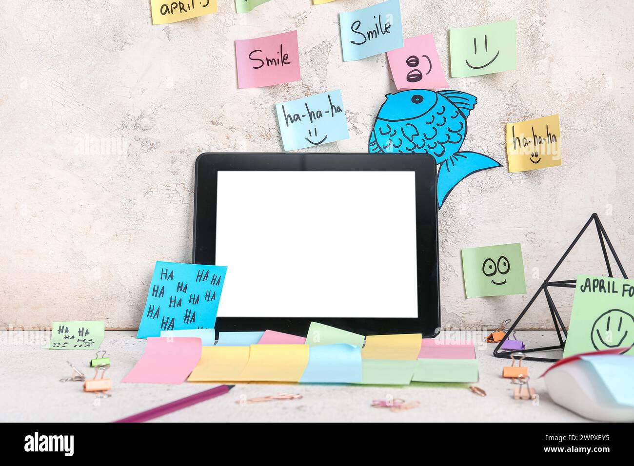 Tablet and sticky notes on grunge background. April Fools Day prank ...