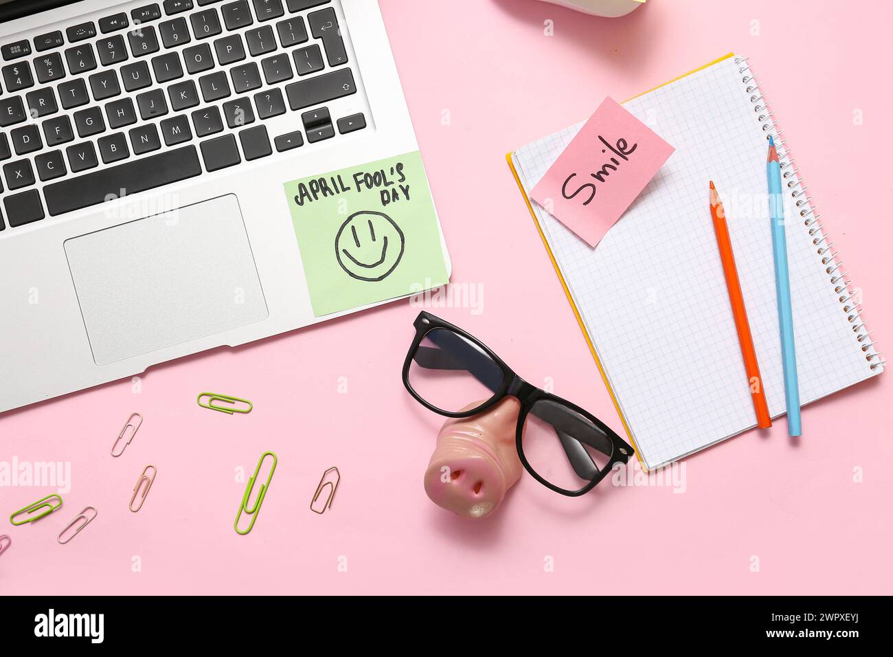 Laptop, notebook and sticky notes on pink background. April Fools Day ...
