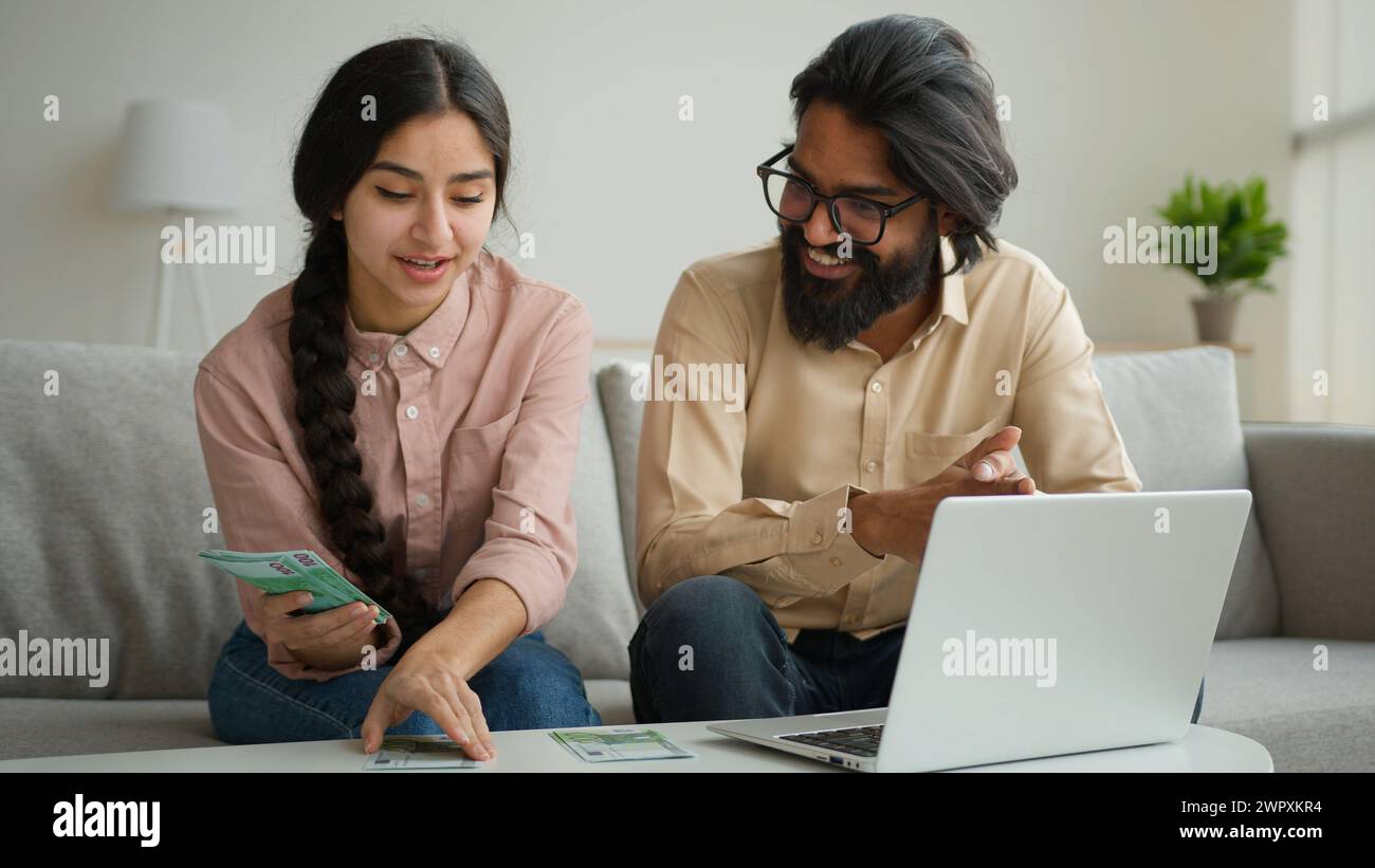 Arabian man Indian woman multiracial couple at home counting euro ...