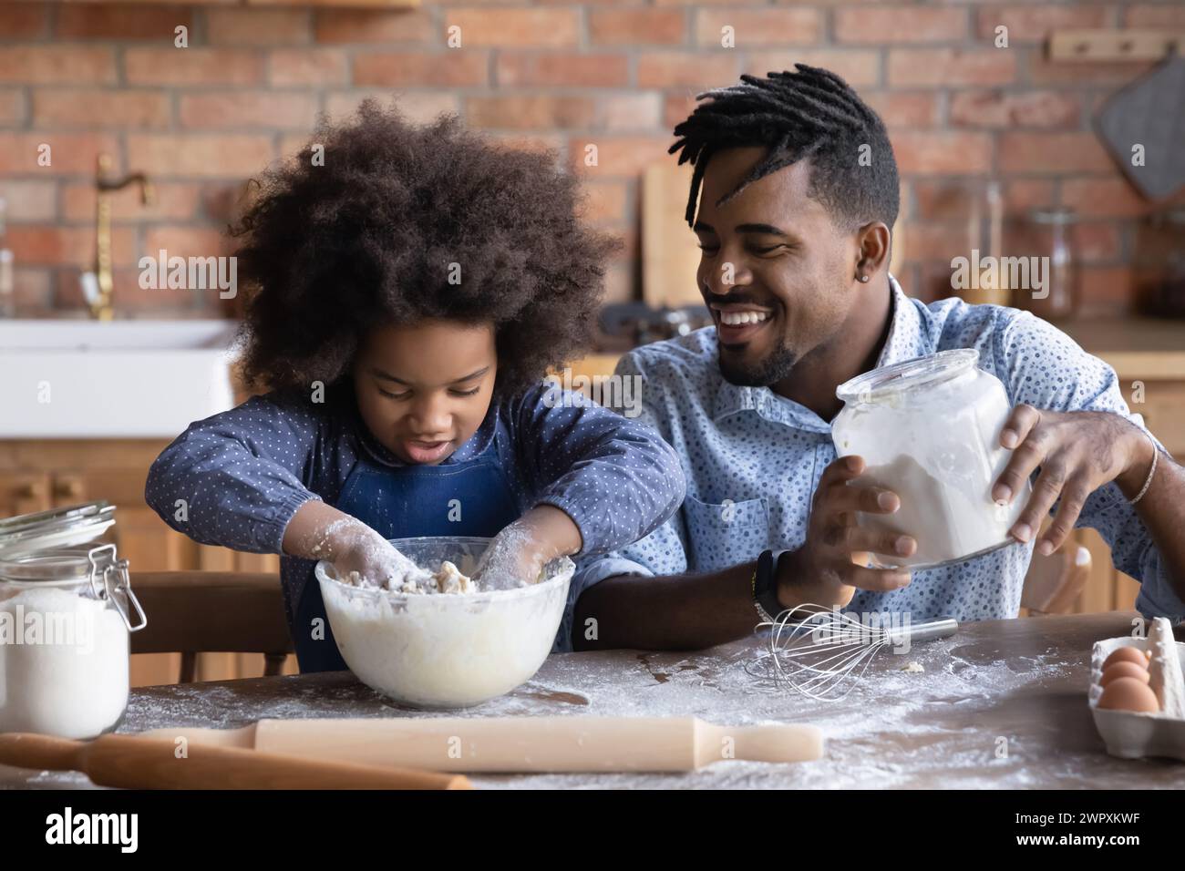 Little African girl kneading dough cooking together with father Stock ...