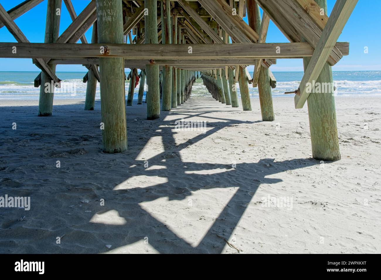 Converging lines of pilings under pier on Atlantic Ocean beach Stock ...