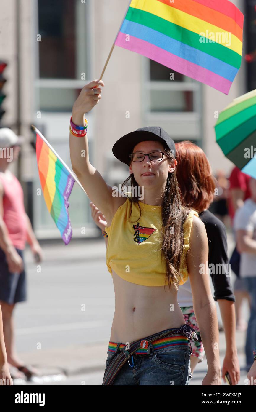 A young woman waving a pride flag participates in the Montreal Pride ...