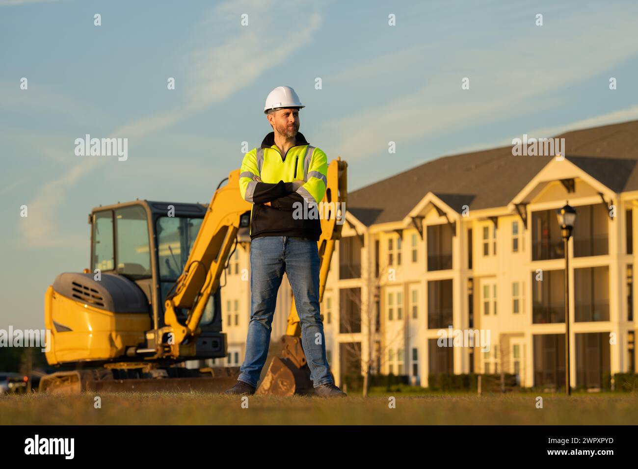 Builder in a construction site. Builder with excavator ready to build ...