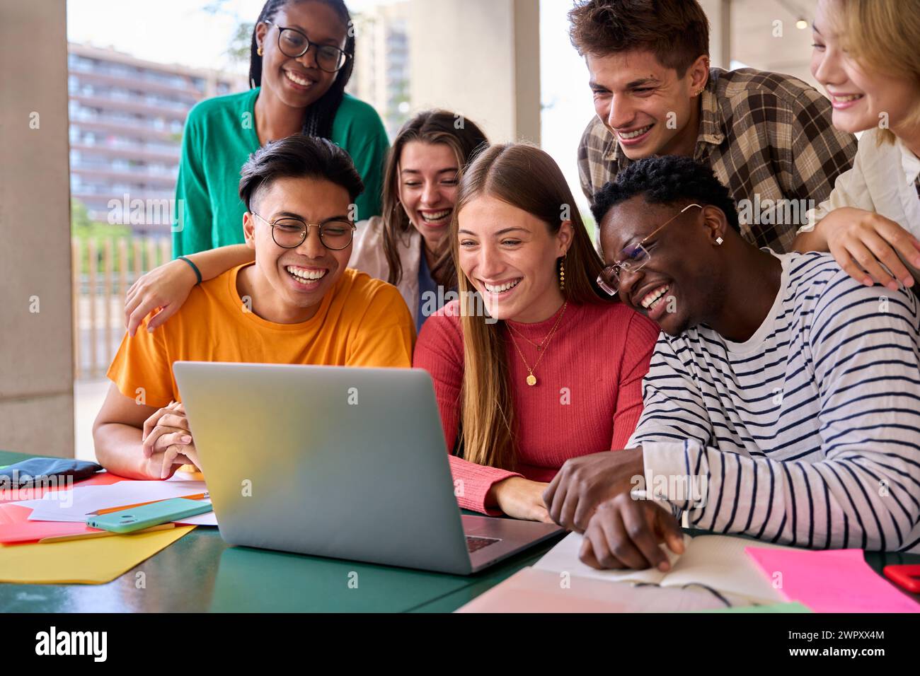 A large group of young multiracial students gathered in classroom ...