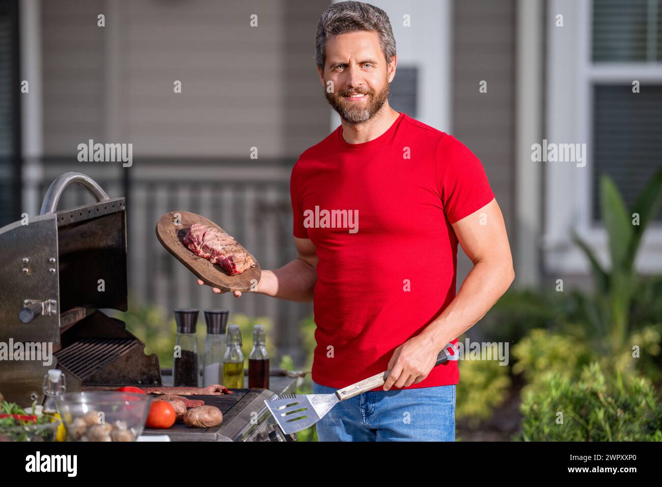 Man at a barbecue grill. Male cook preparing barbecue outdoors. Bbq ...