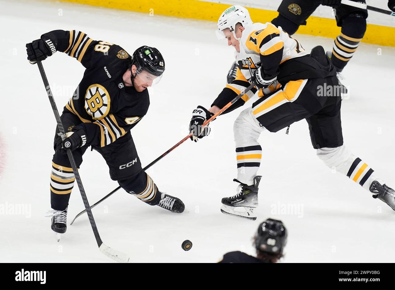 Boston Bruins' Matt Grzelcyk (48) and Pittsburgh Penguins' Jesse Puljujarvi (18) battle for the ...
