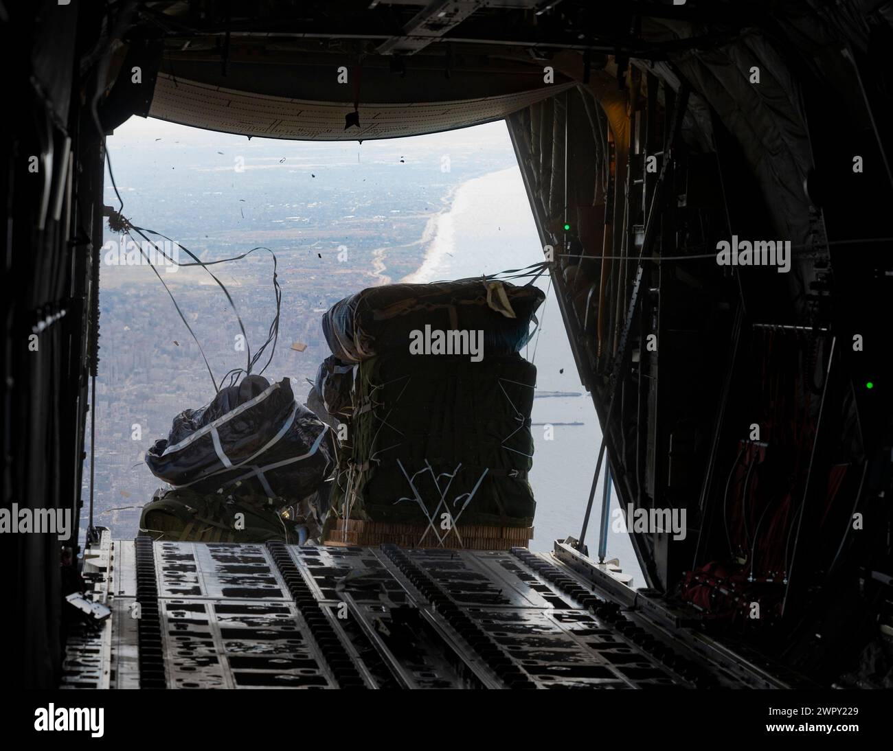 A U.S. Air Force C-130J Super Hercules conducts an airdrop of ...