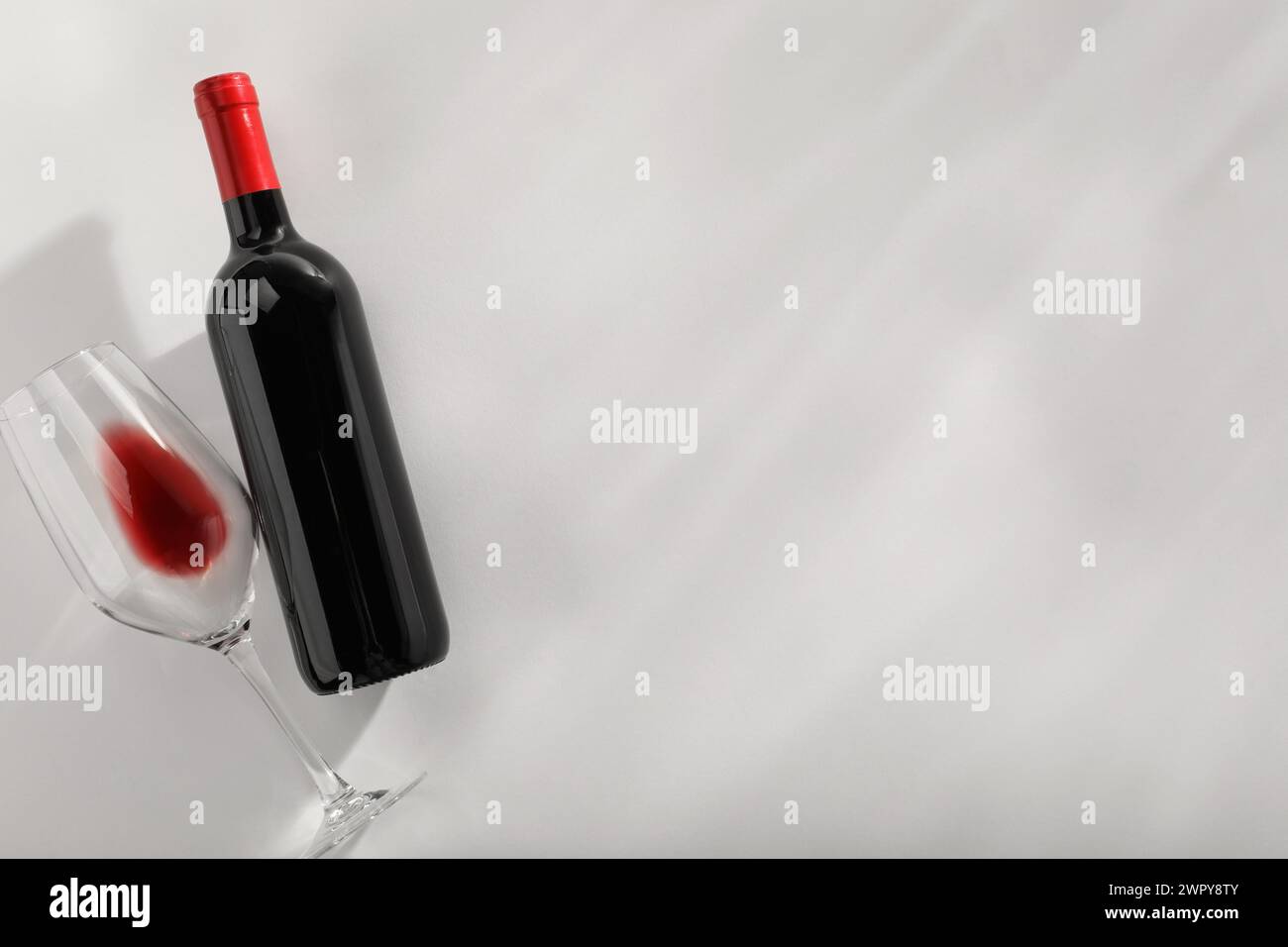 Bottle of expensive red wine and wineglass on light grey background ...