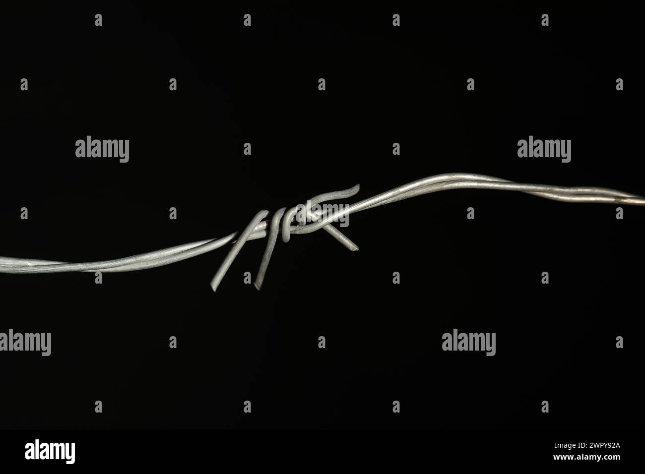 Shiny metal barbed wire on black background Stock Photo - Alamy