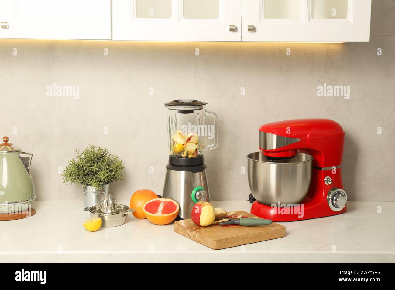 Modern red stand mixer, blender, artificial plant and different ...