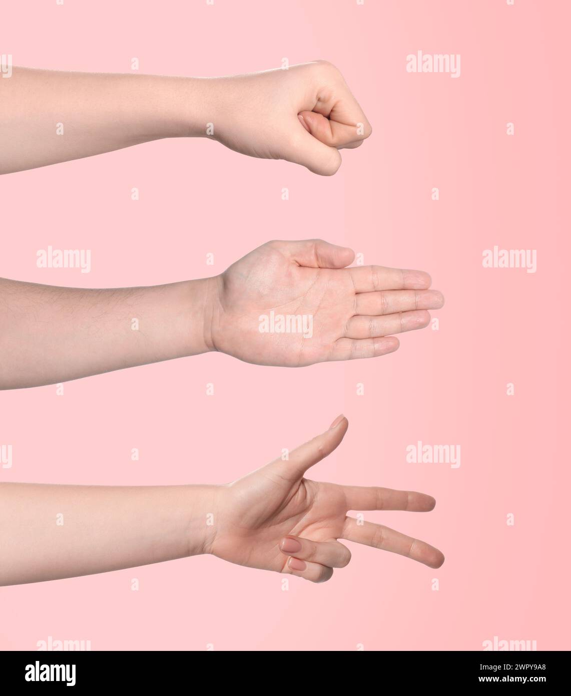 People playing rock, paper and scissors on pink background, closeup ...