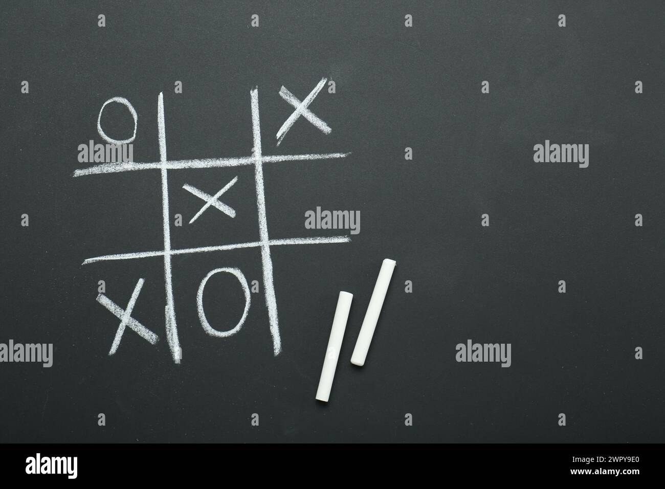 Tic tac toe game drawn on chalkboard, top view Stock Photo - Alamy