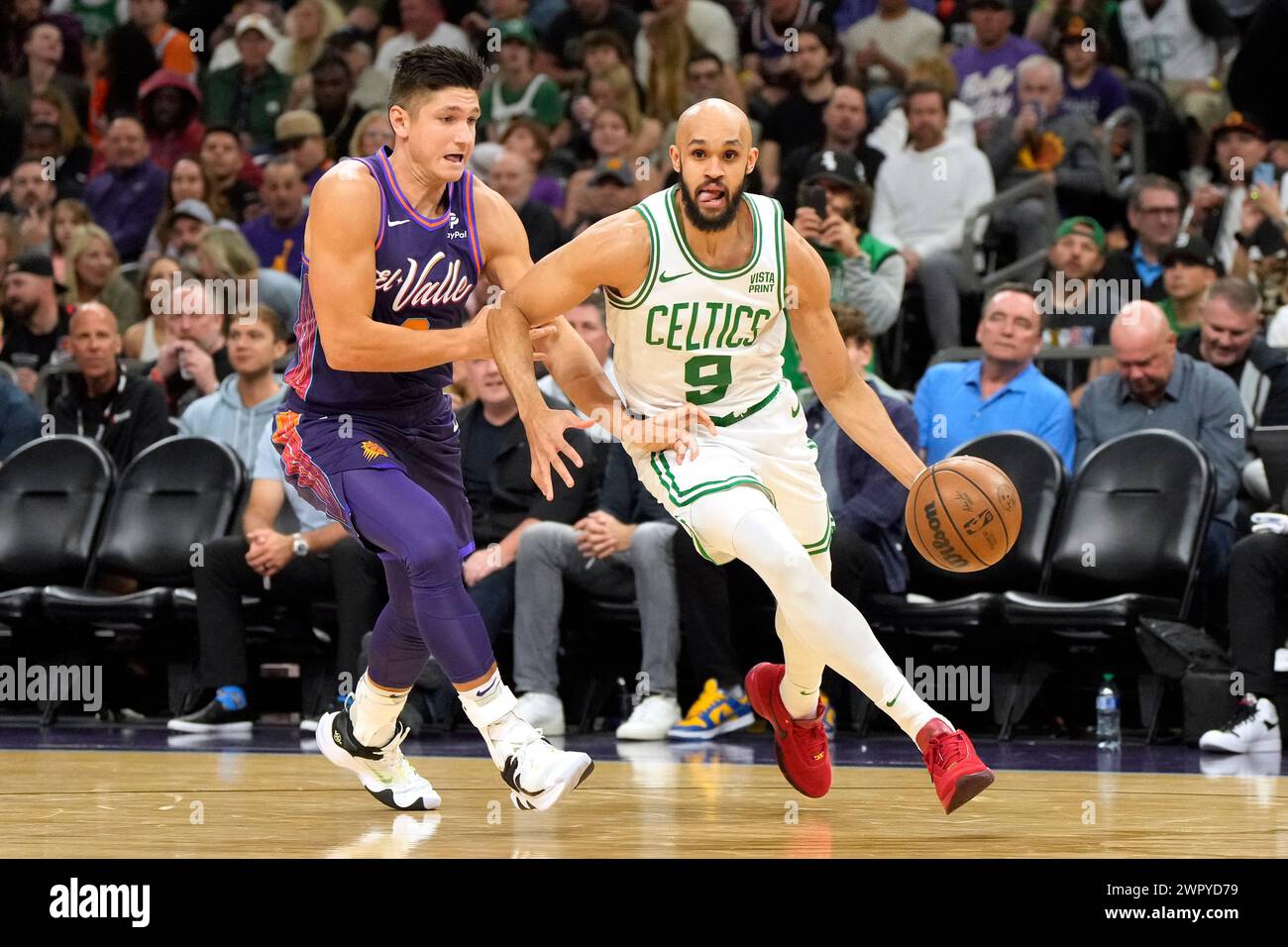Boston Celtics guard Derrick White (9) drives past Phoenix Suns guard ...