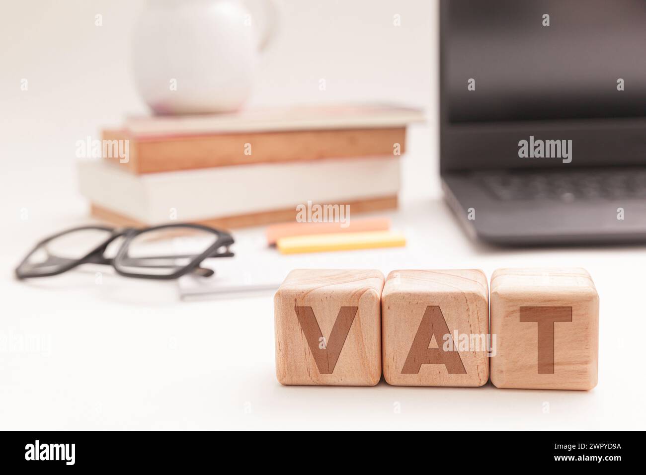 Wooden block with text VAT and background office behind Stock Photo - Alamy