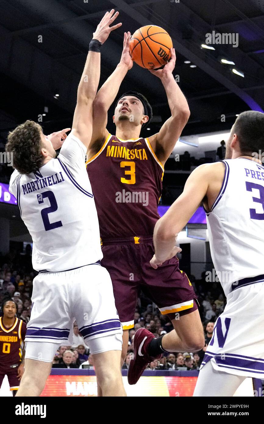 Minnesota forward Dawson Garcia, center, shoots against Northwestern forward Nick Martinelli ...