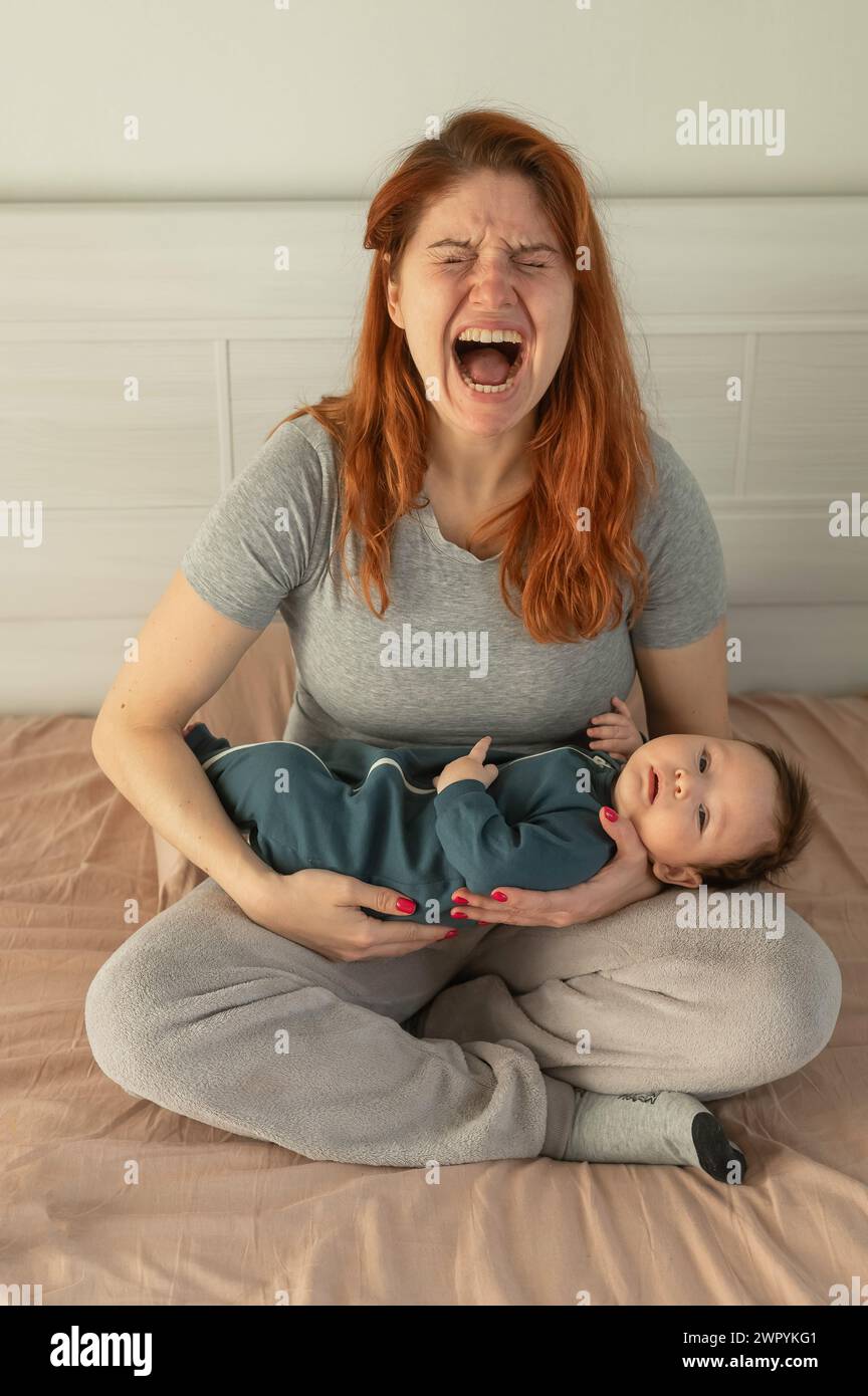 Vertical photo. A woman holds a child in her arms and cries. Postpartum depression Stock Photo ...