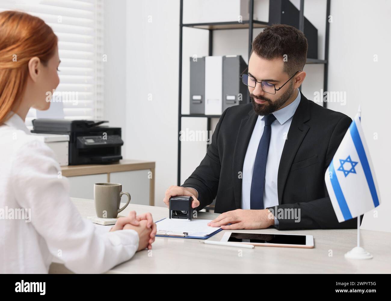 Immigration to Israel. Embassy worker approving visa application form ...