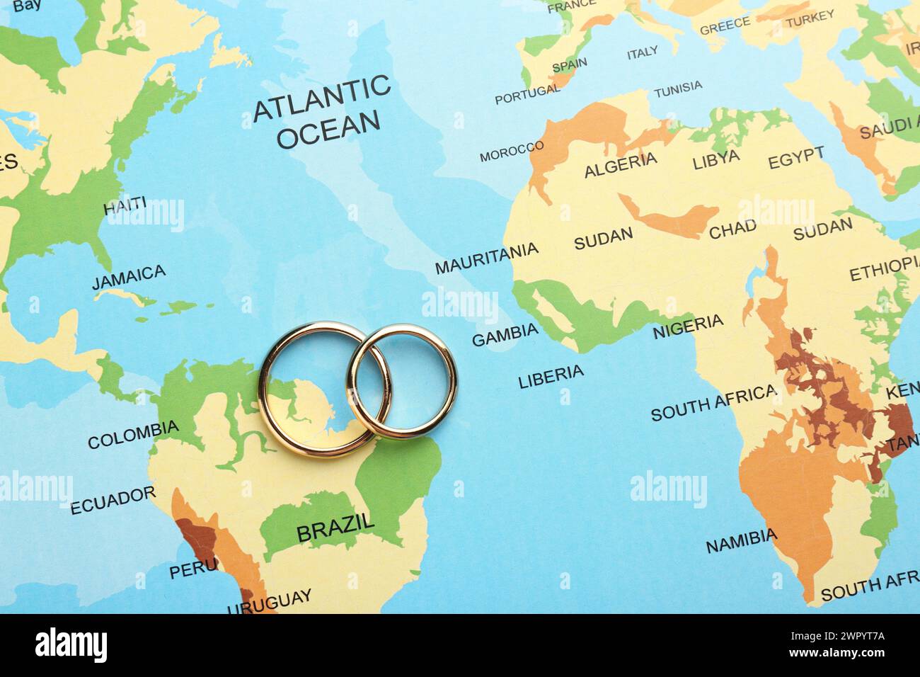 Honeymoon concept. Two golden rings on world map, top view Stock Photo ...