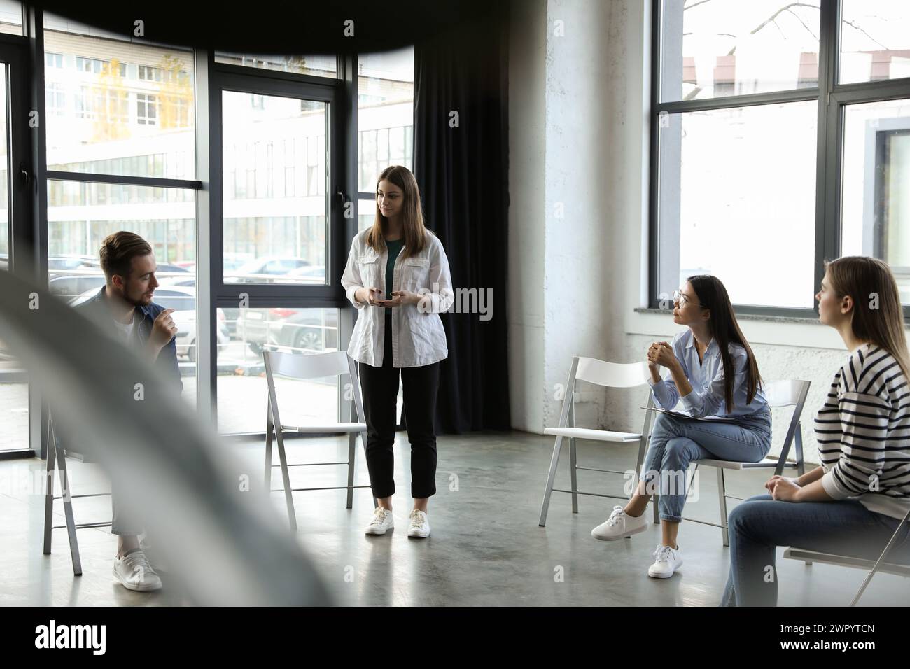 Psychotherapist working with patients in group therapy session indoors ...