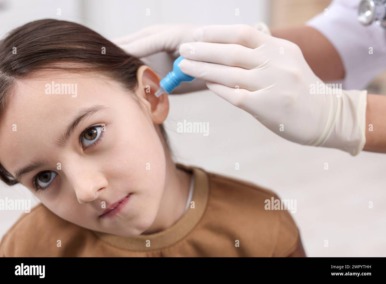 Doctor applying medical drops into girl's ear indoors Stock Photo - Alamy