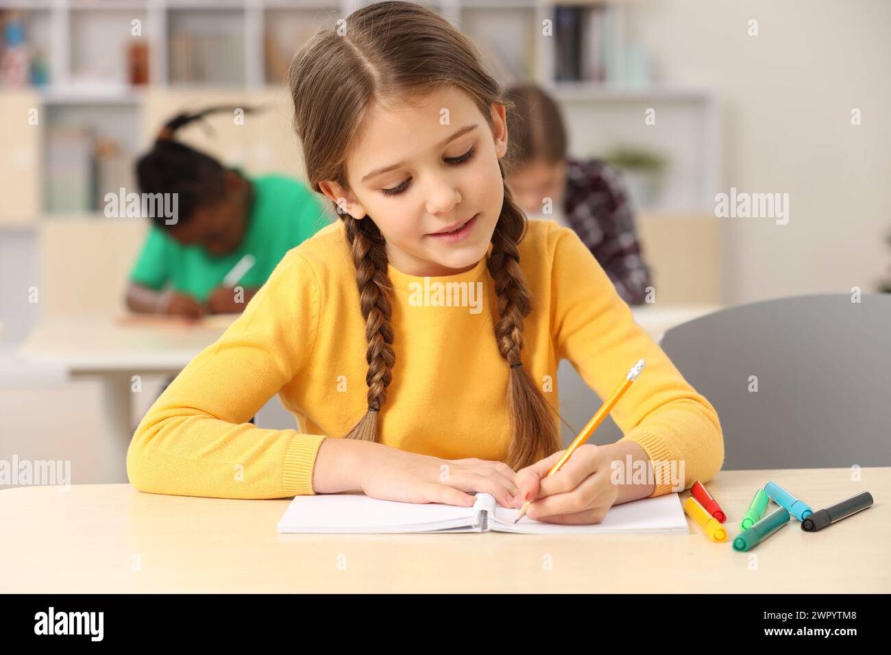 Cute little girl studying in classroom at school Stock Photo - Alamy