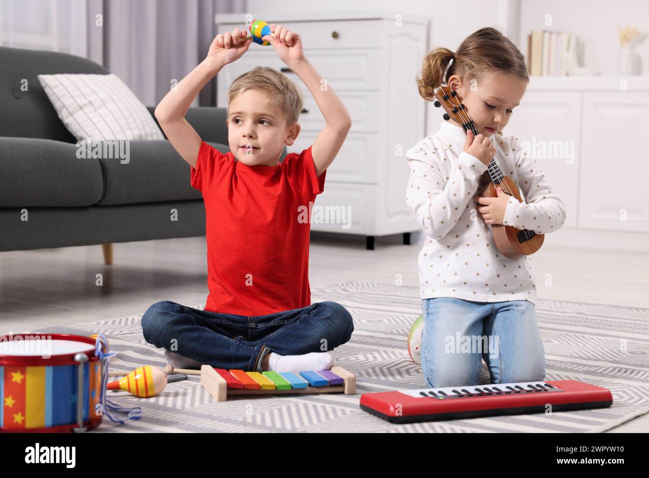 Little children playing toy musical instruments at home Stock Photo - Alamy