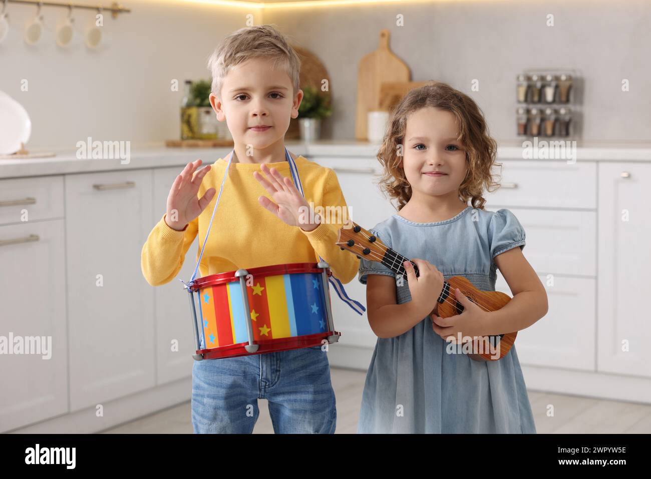 Little children playing toy musical instruments in kitchen Stock Photo ...