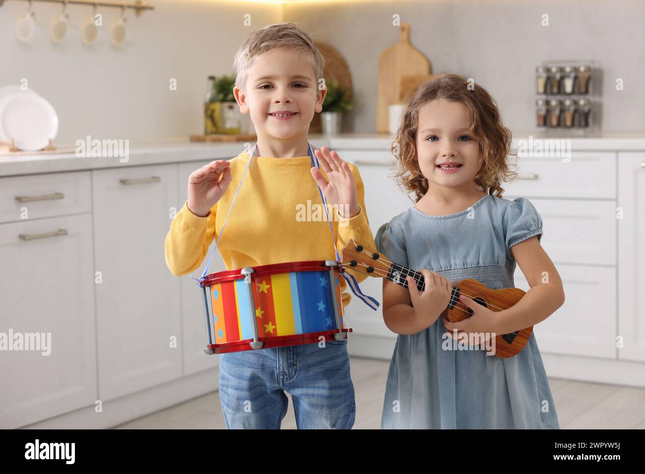 Little children playing toy musical instruments in kitchen Stock Photo ...