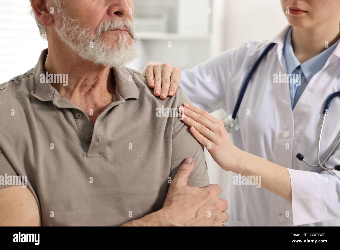Arthritis symptoms. Doctor examining patient with shoulder pain in ...