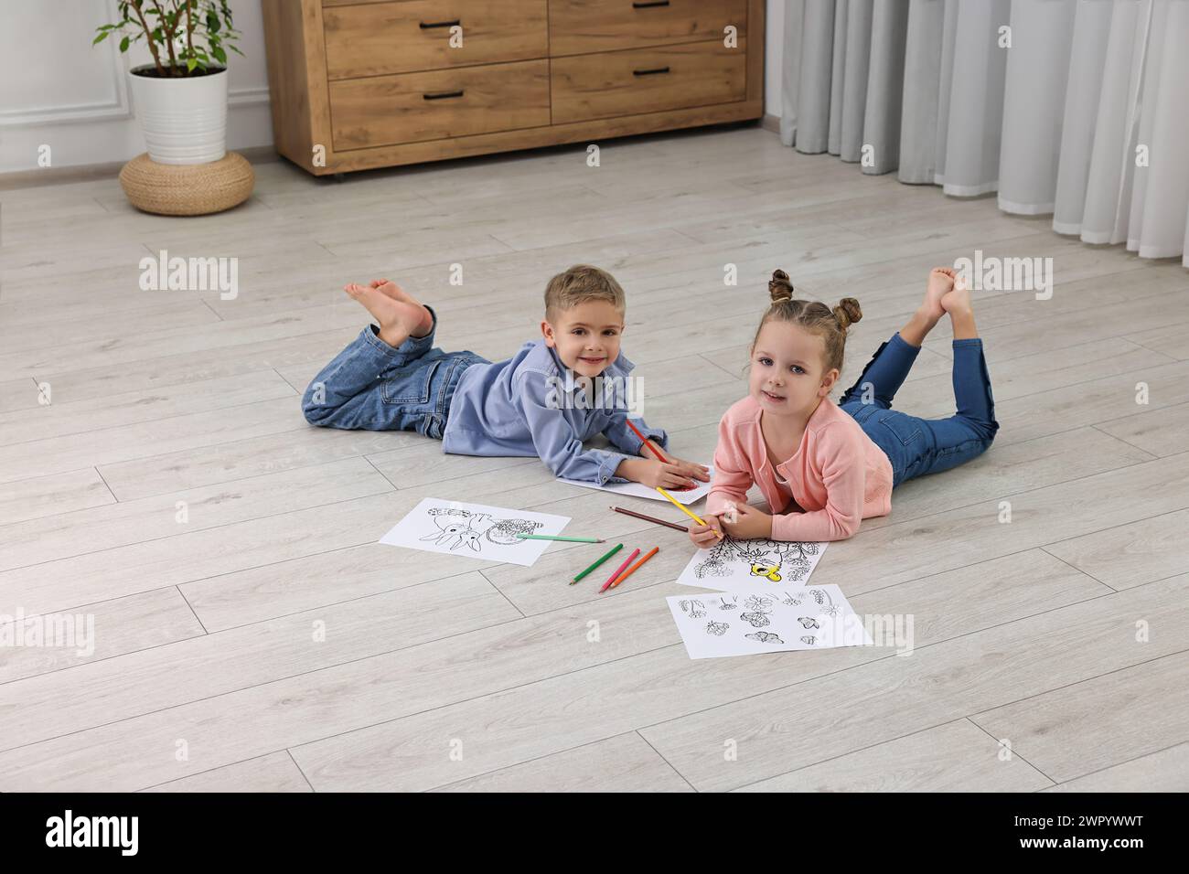 Cute little children coloring on warm floor at home. Heating system ...