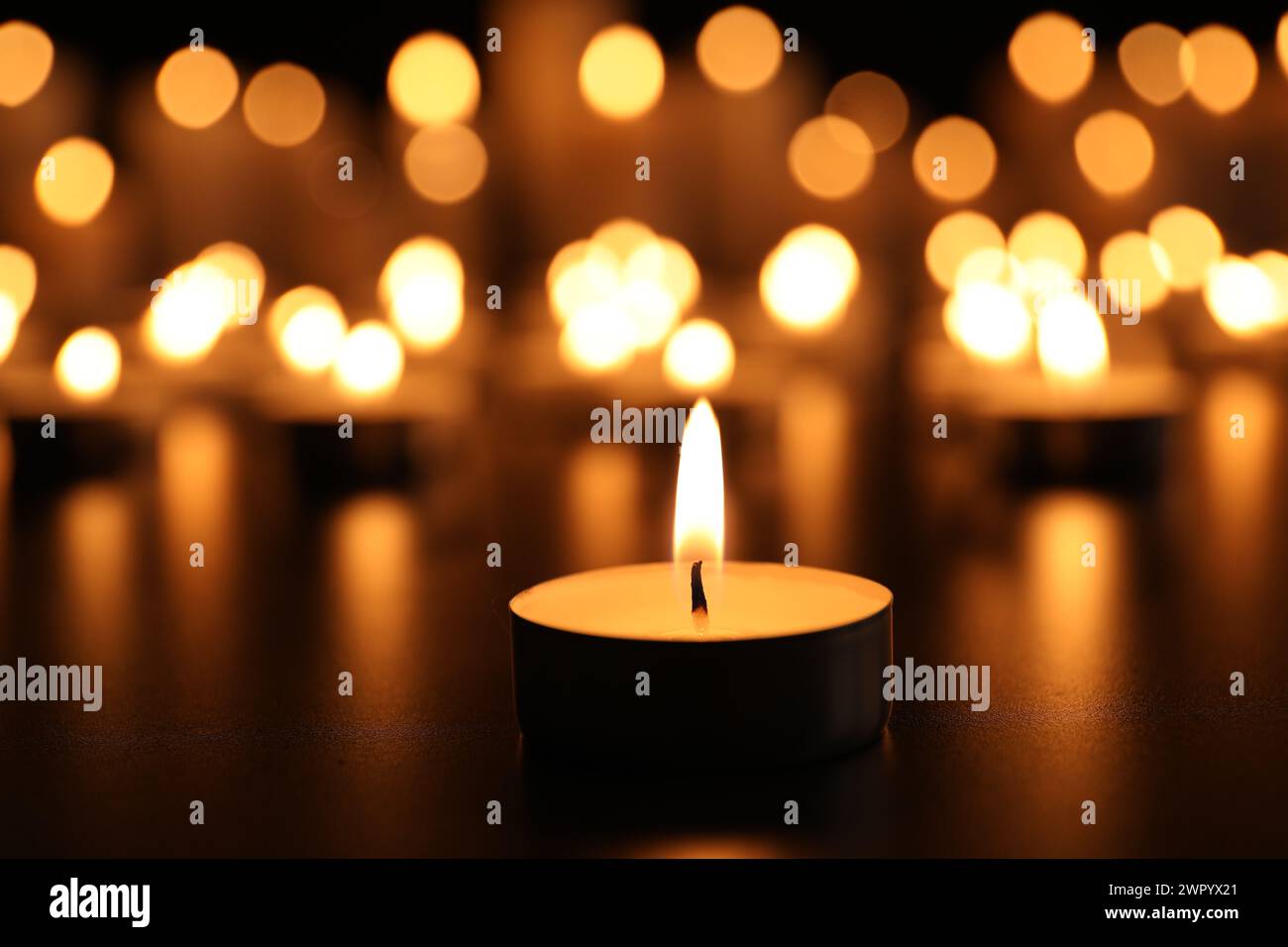 Burning candle on black table. Memory day Stock Photo - Alamy