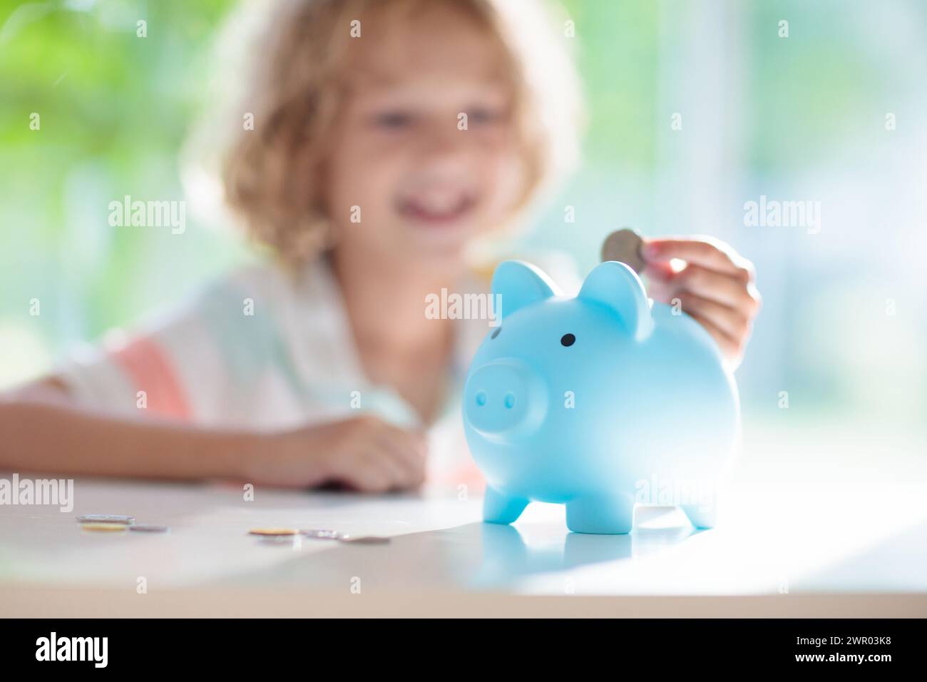 Child putting coin in piggy bank. Kids learn about money. Savings and ...