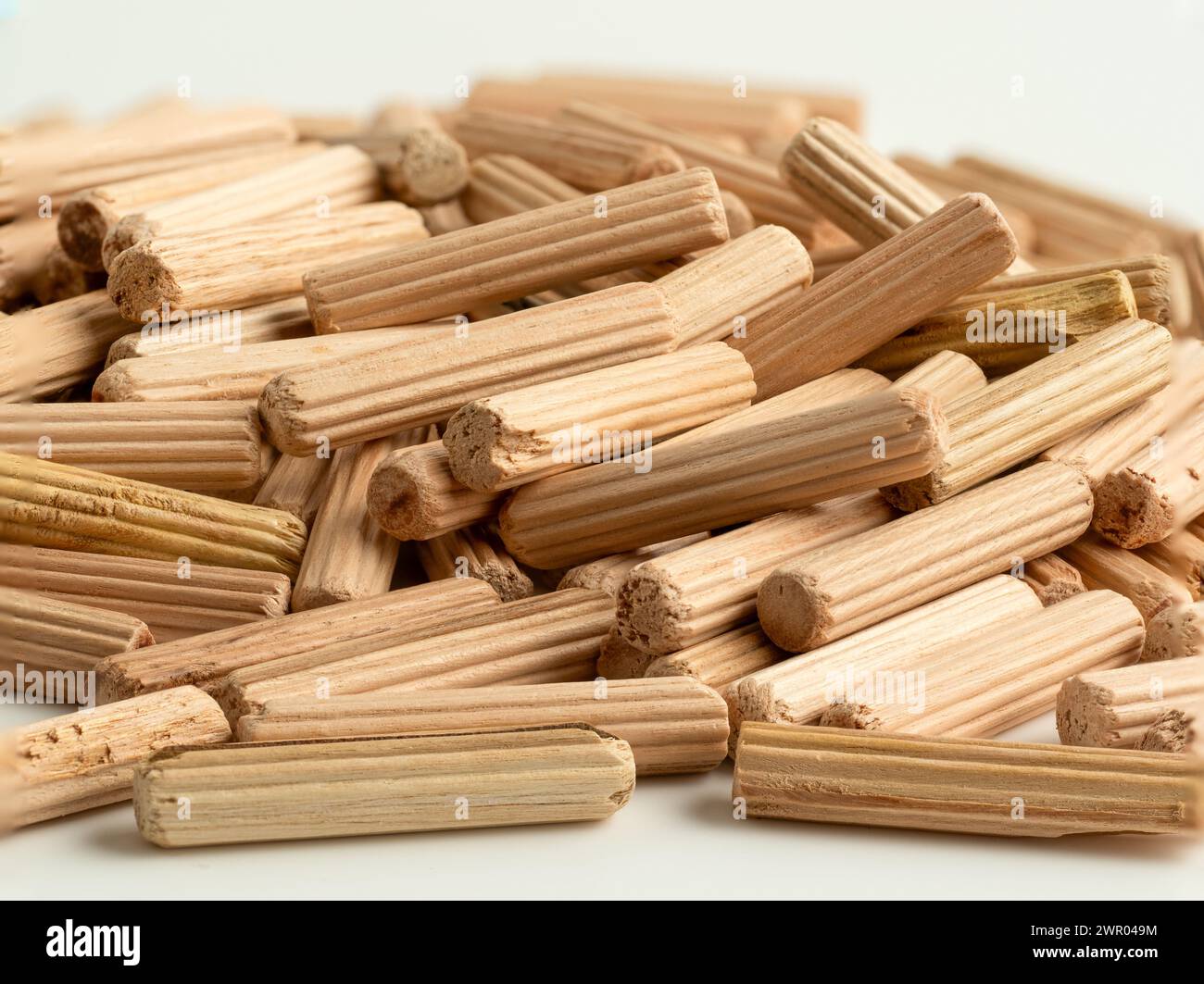close up of a pile of Wooden fluted Dowel pins isolated on a white ...