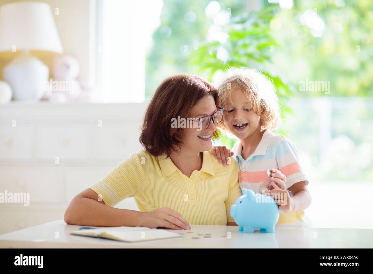 Child putting coin in piggy bank. Kids learn about money. Savings and ...