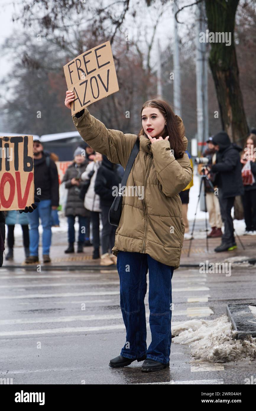 Young Ukrainian girl shows a banner "Free Azov" on a public ...