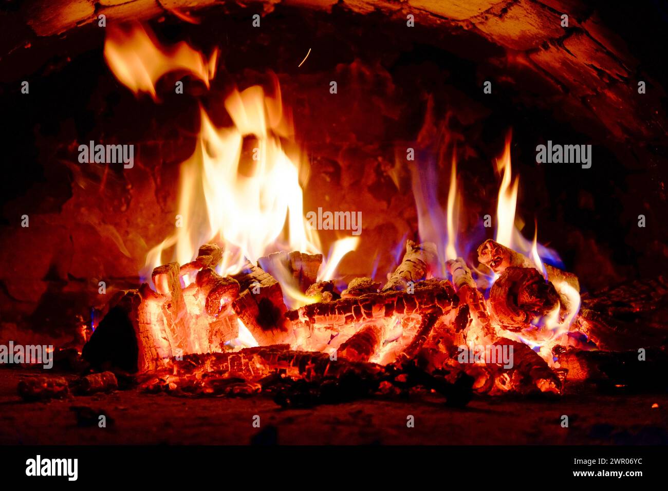 The fiery glow emanates from burning wood, lighting up the area Stock ...