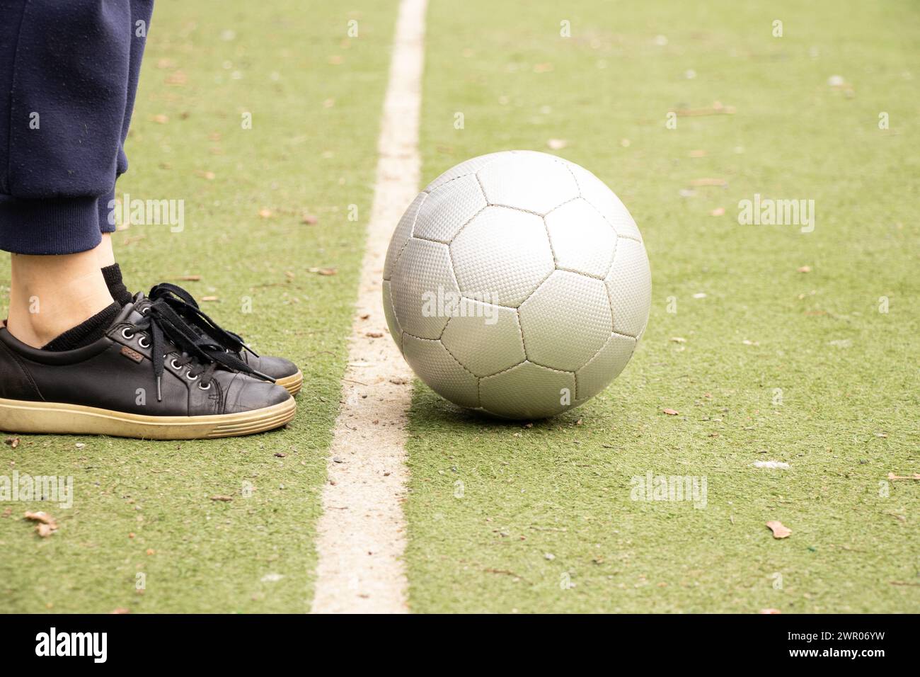 Women's legs on a football field and a gray soccer ball in Ukraine ...