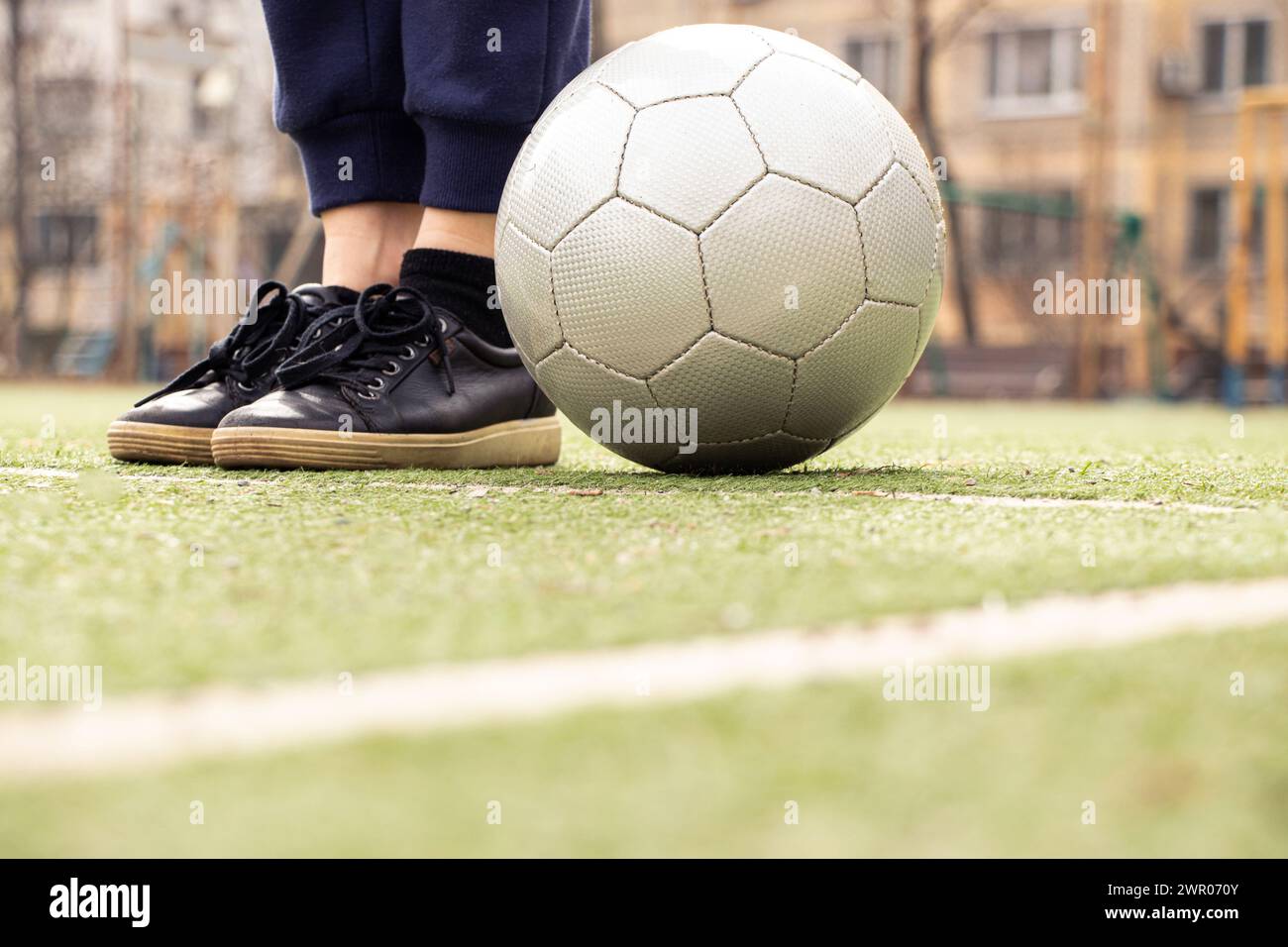 Women's legs on a football field and a gray soccer ball in Ukraine ...