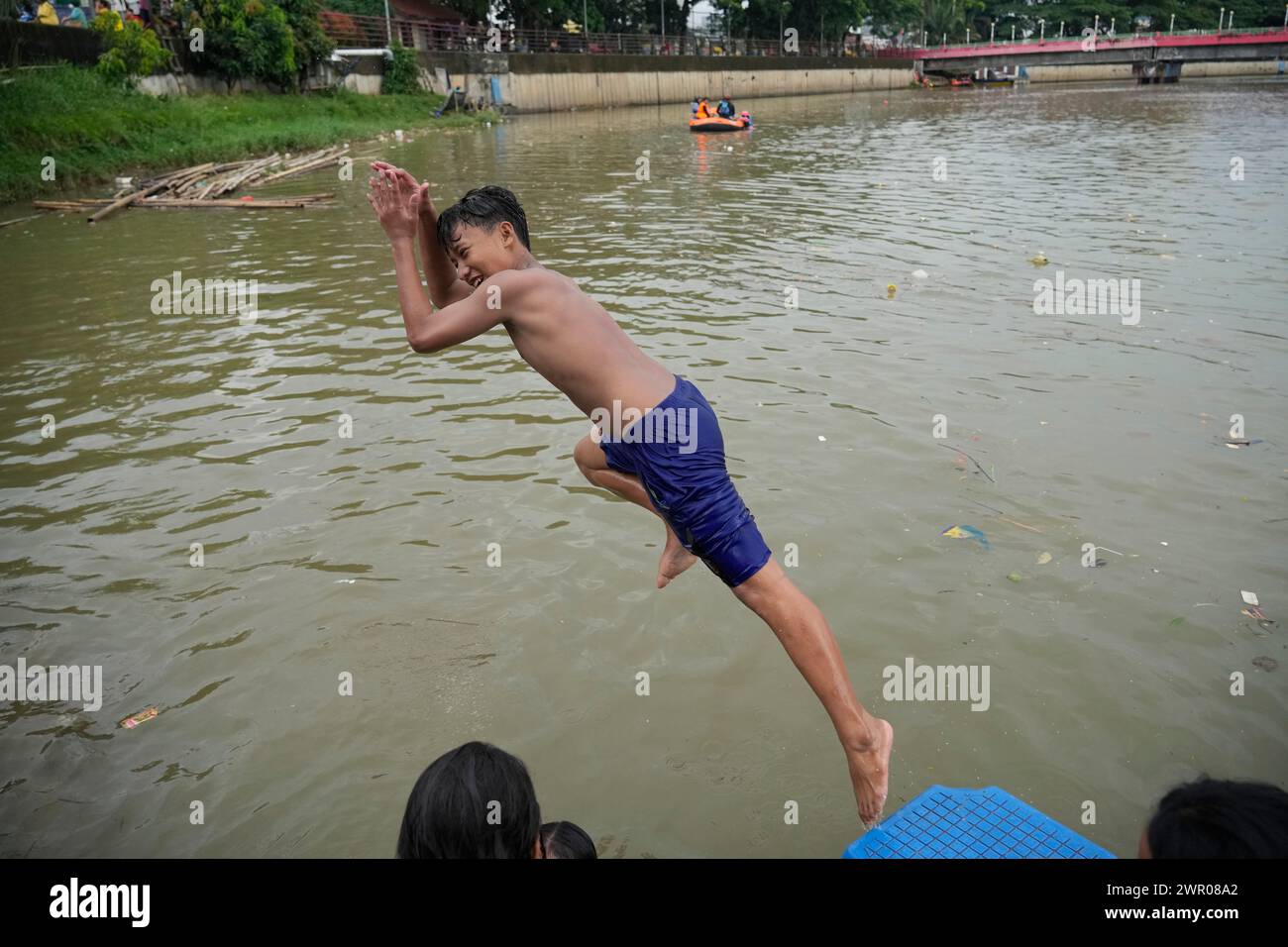 A youth jumps into the Cisadane River, ahead of the holy fasting month ...