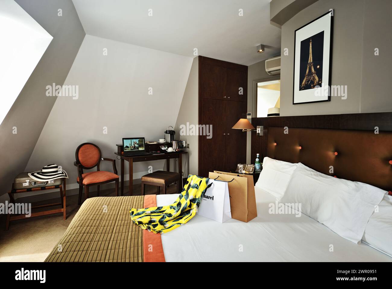 A spacious attic hotel room in Paris, France, decorated with framed ...