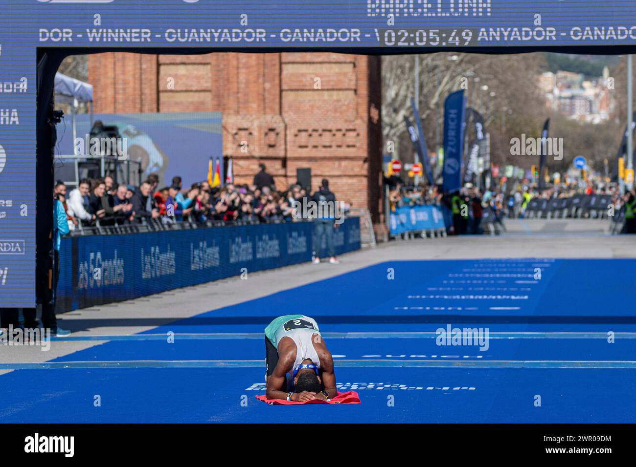 A runner celebrates after crossing the finish line of the Zurich Marató ...