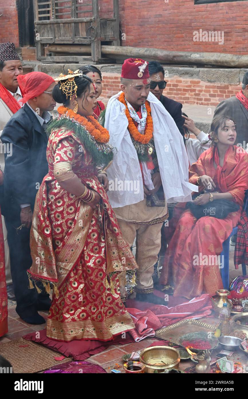 Nepalese couple getting married in a typical newari wedding in the courtyard of a hindu temple ...