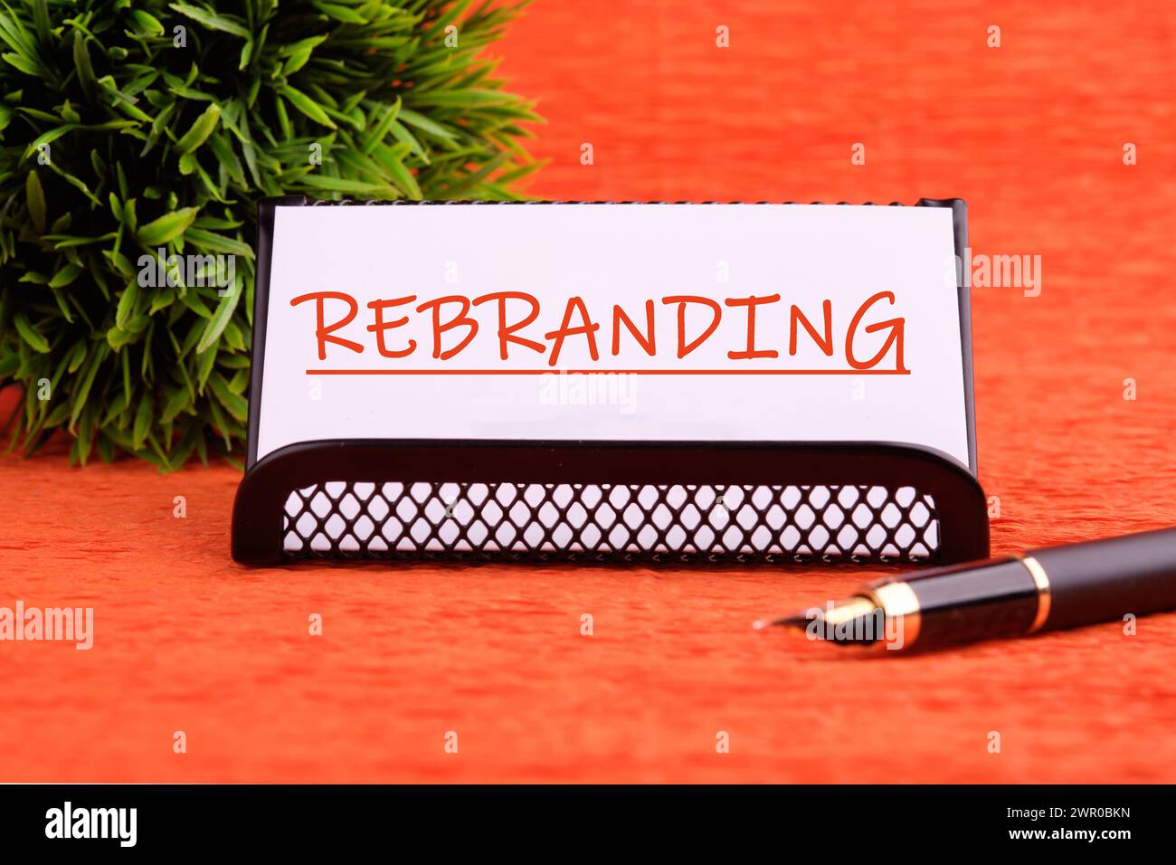 rebranding word written on a white card on a stand on an orange ...