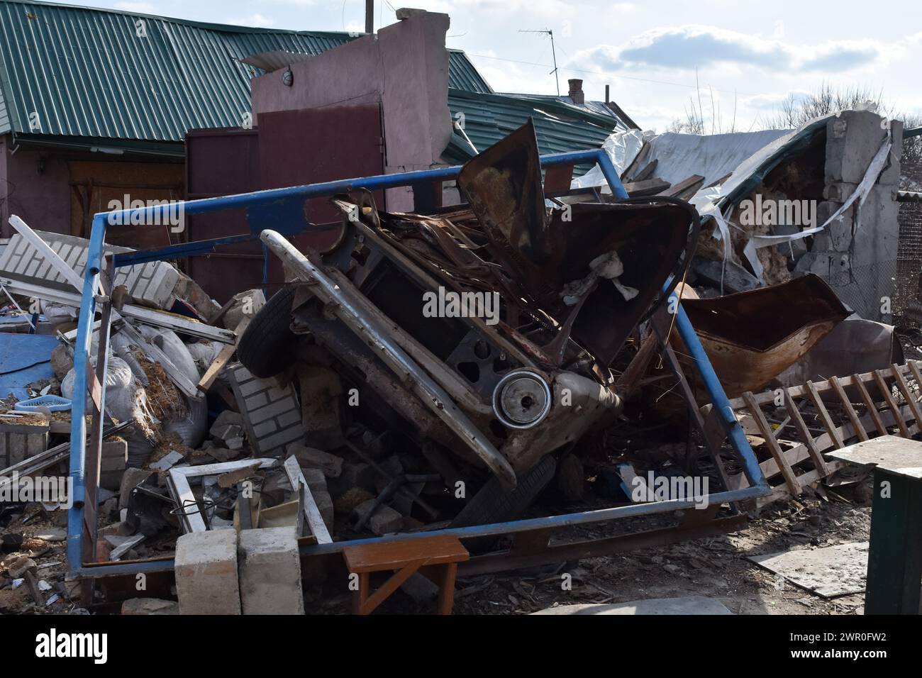 A destroyed car seen at the backyard of a private house that was ...